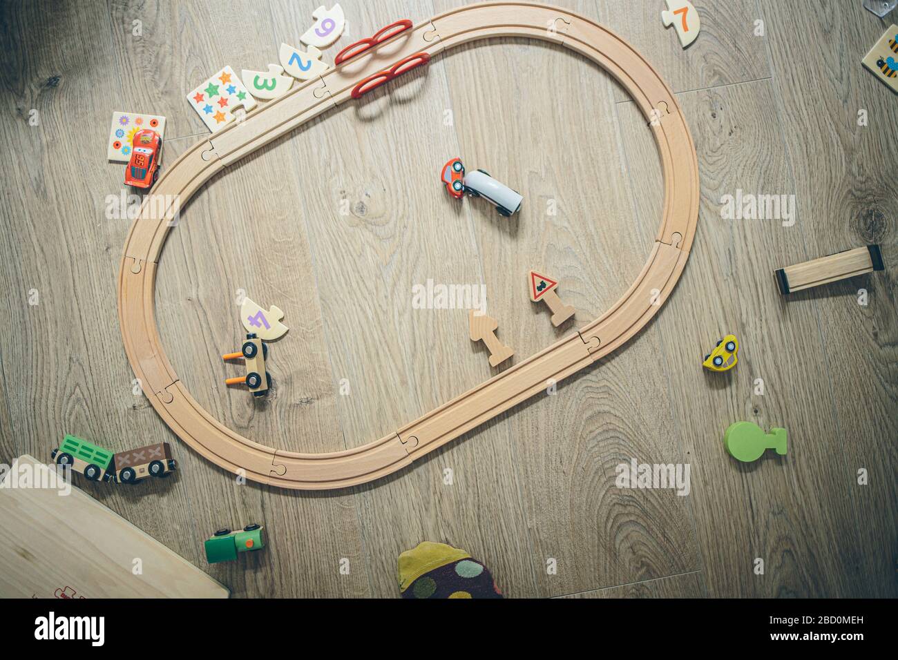 Oval toy wooden railway circuit on a domestic house floor with untidy ...