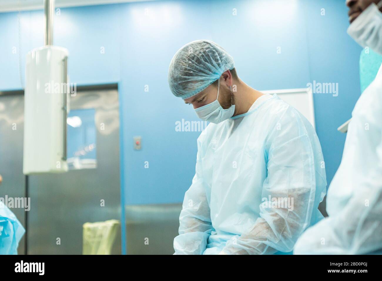 Portrait of a tired surgeon in medical uniform and mask after the ...