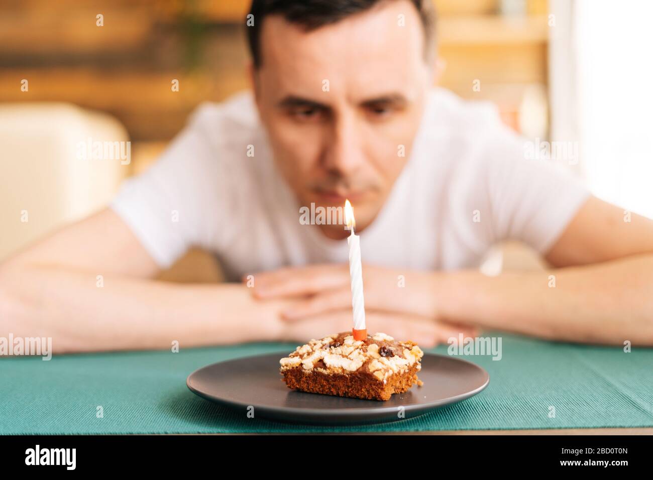 Sad lonely young man celebrating birthday alone, sitting at the ...