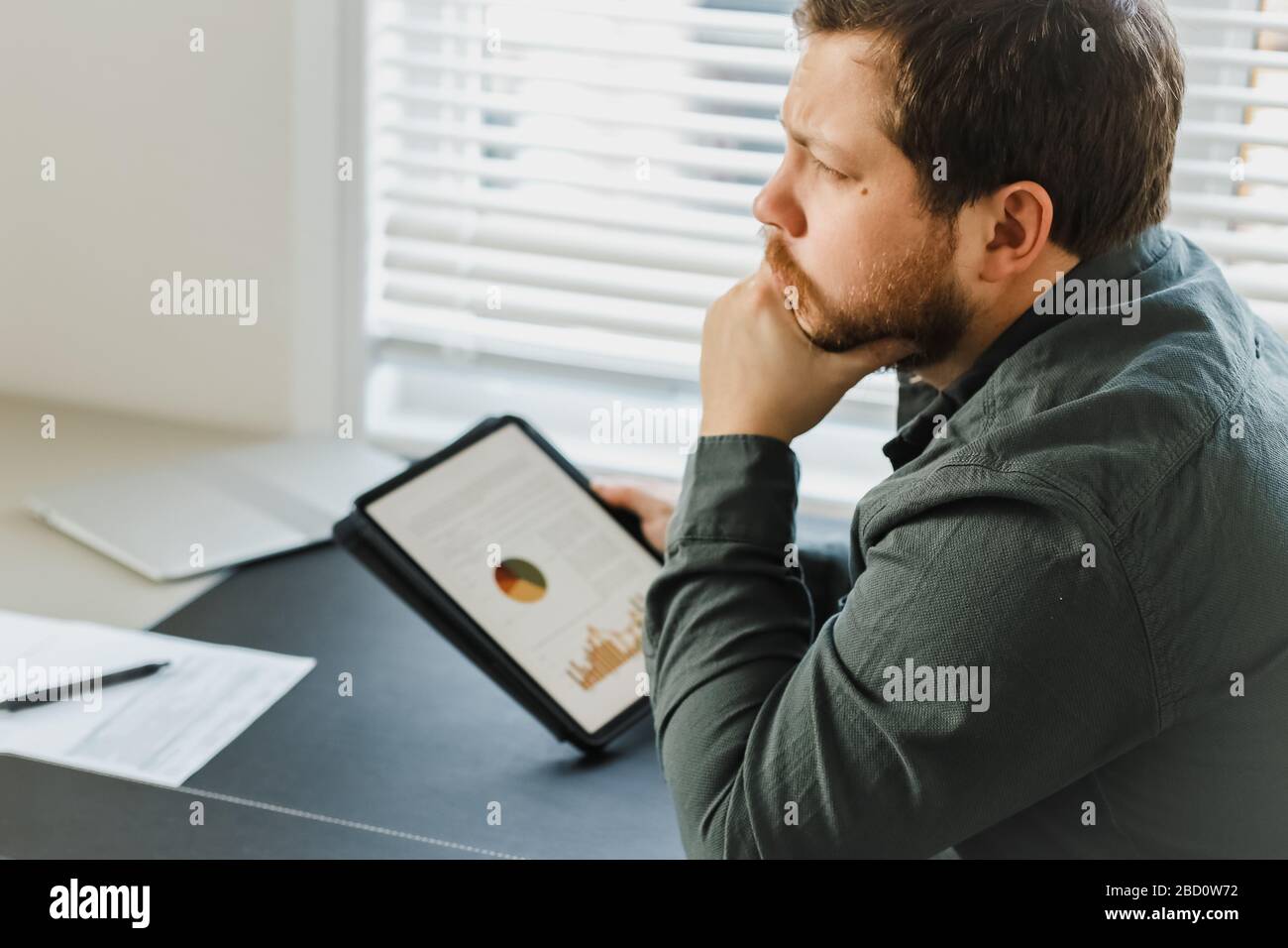 Closeup engineer using tablet and looking at graphs with diagrams on ...