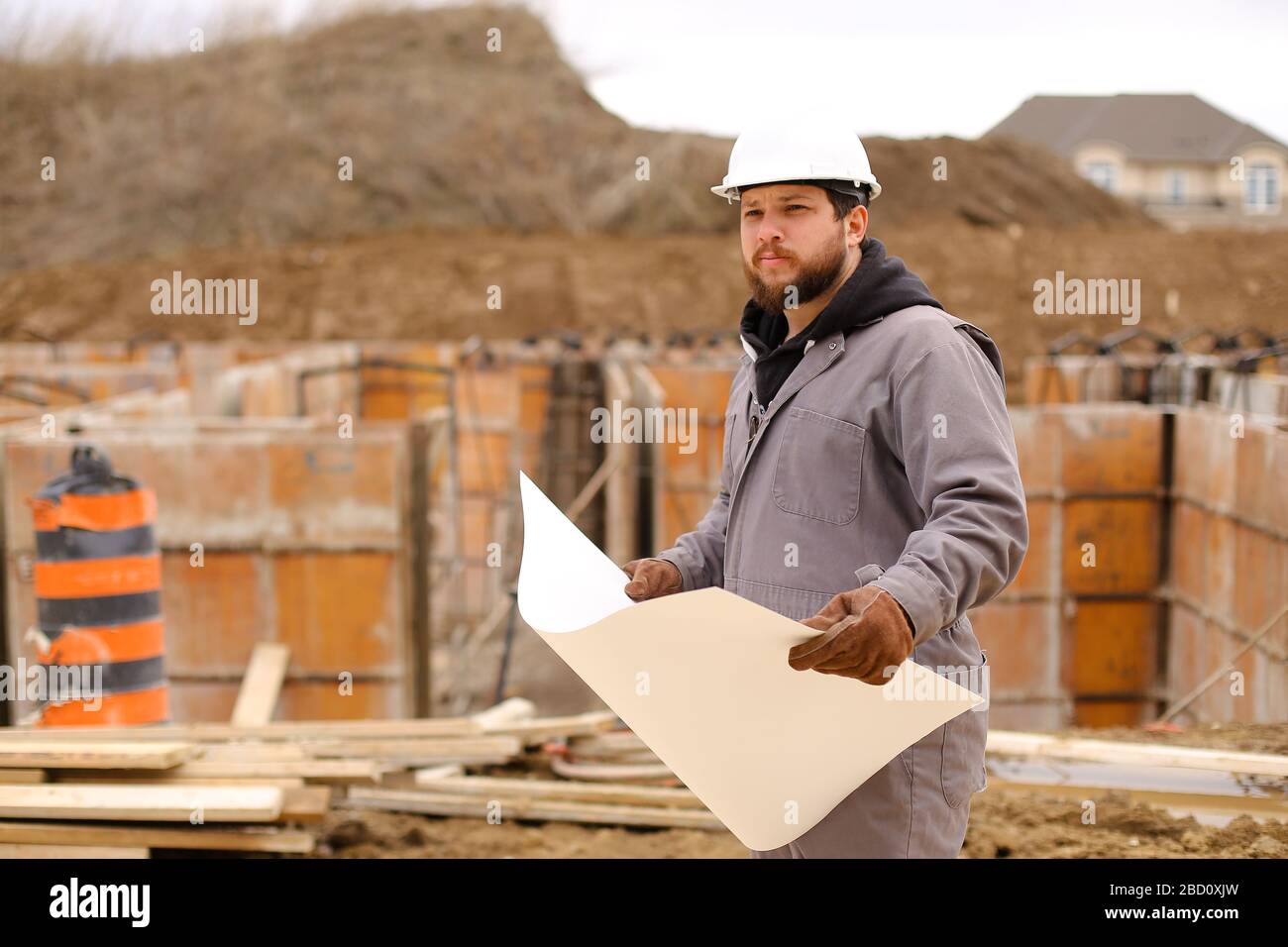 Male engineer holding drawing plan of hause at construction site Stock ...