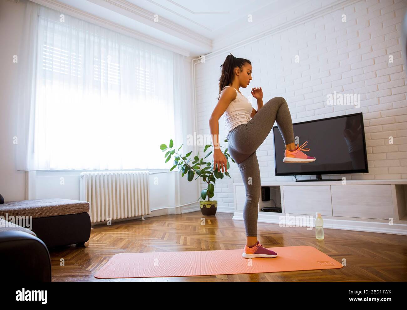 Cute young attractive woman practicing exercises at home Stock Photo ...