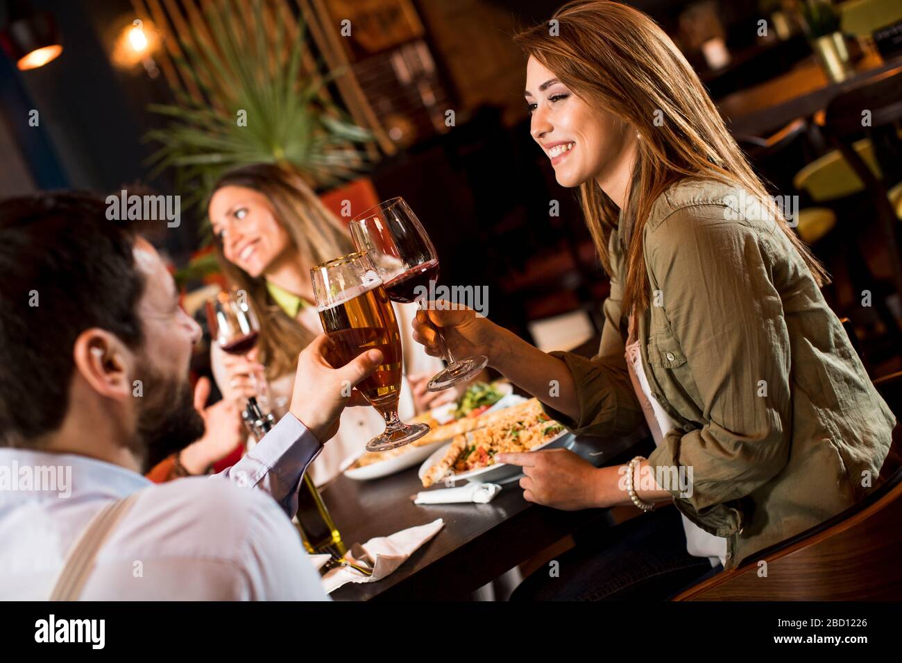 Group of young people having dinner in the restaurant Stock Photo - Alamy