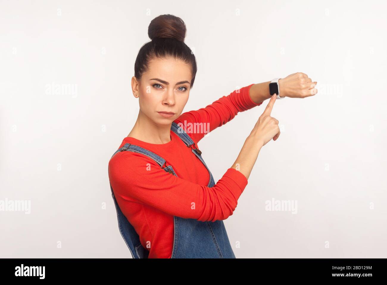 Too late, hurry up! Portrait of displeased impatient girl with hair bun ...