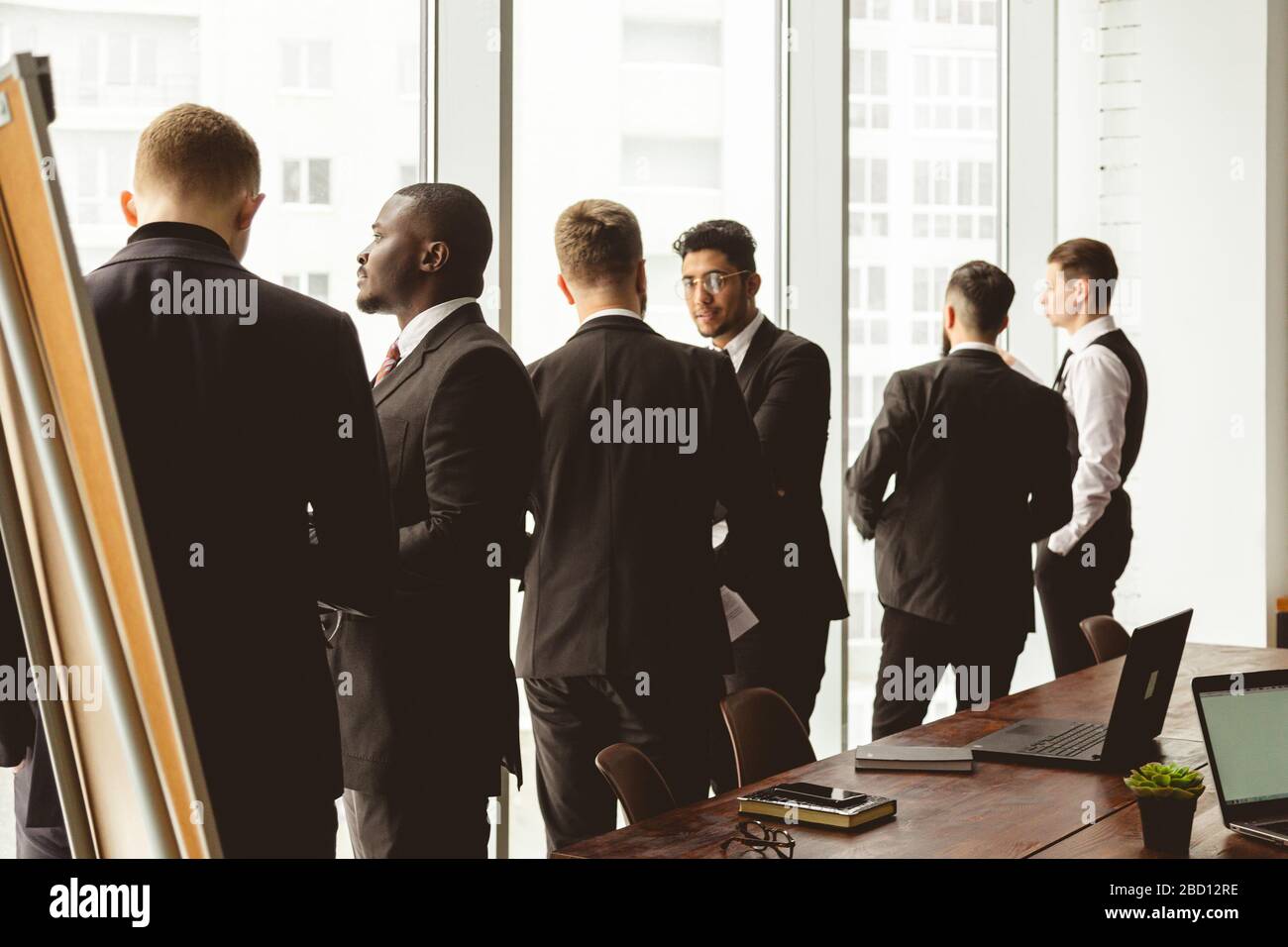 Silhouettes of people against the window. A team of young businessmen ...