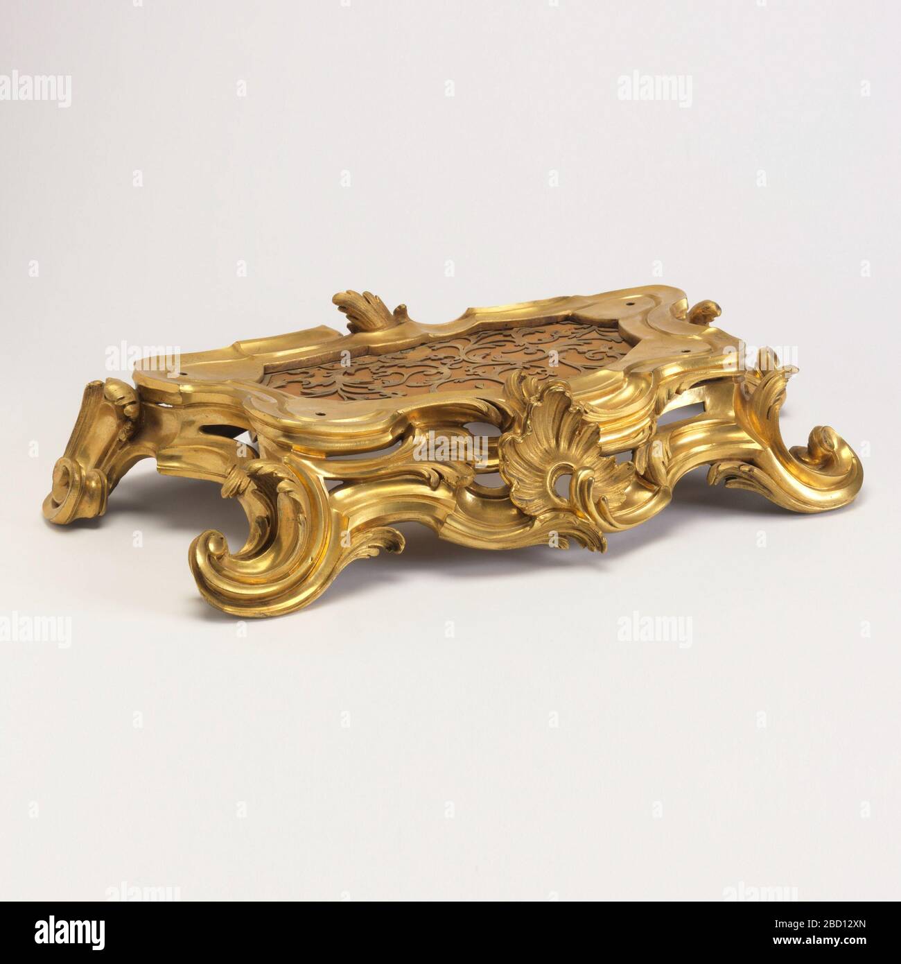 Musical clock stand. formed of a series of S-curves in ormolu ...