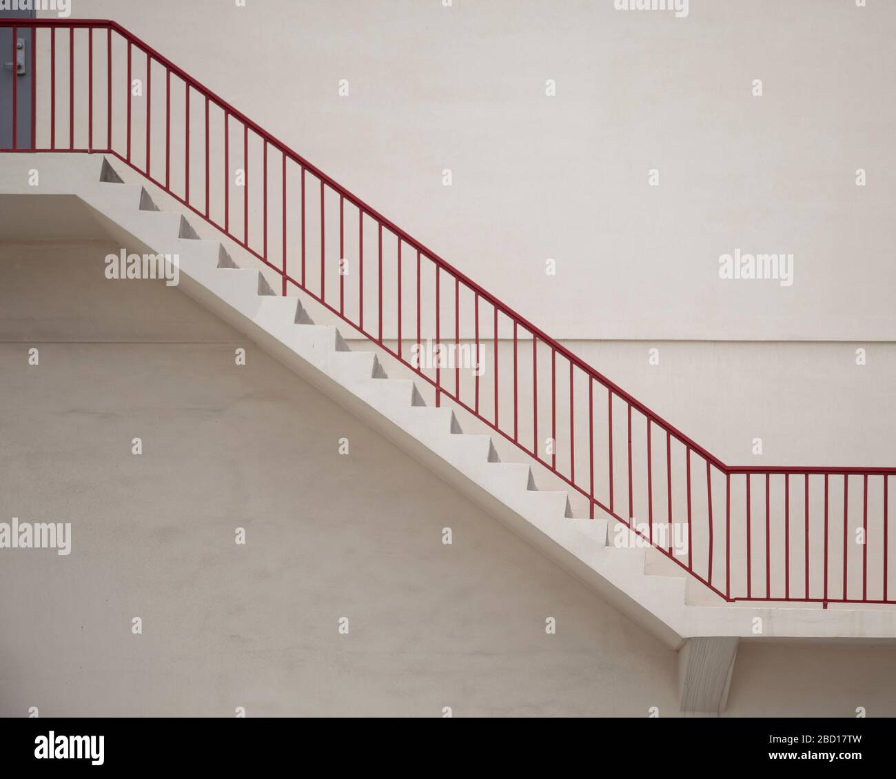 A View of stairs with red metal railings against a flat wall Stock ...