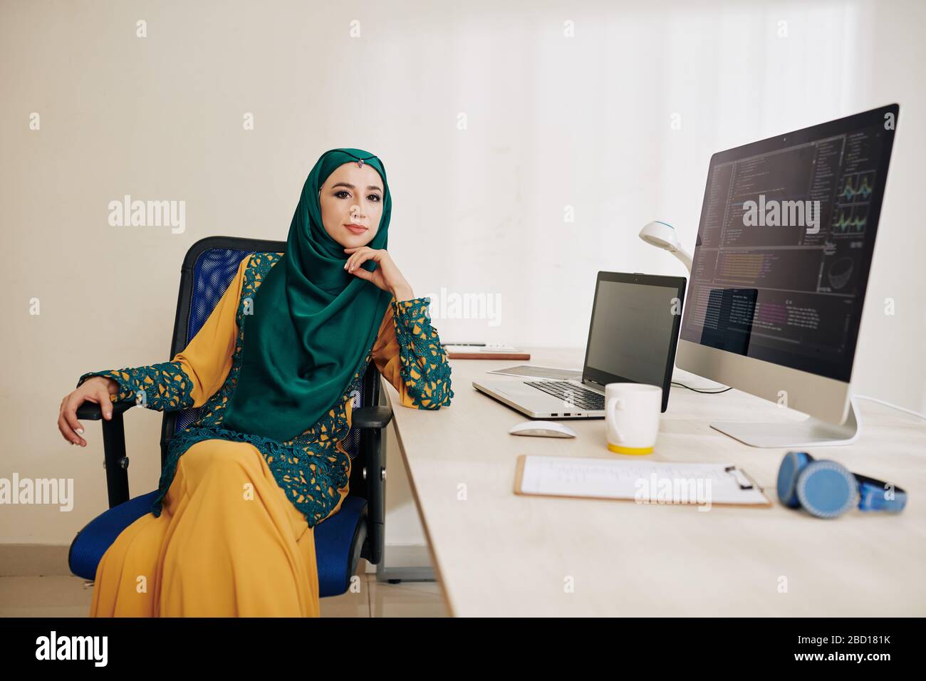 Confident muslim female software developer in traditional dress in ...