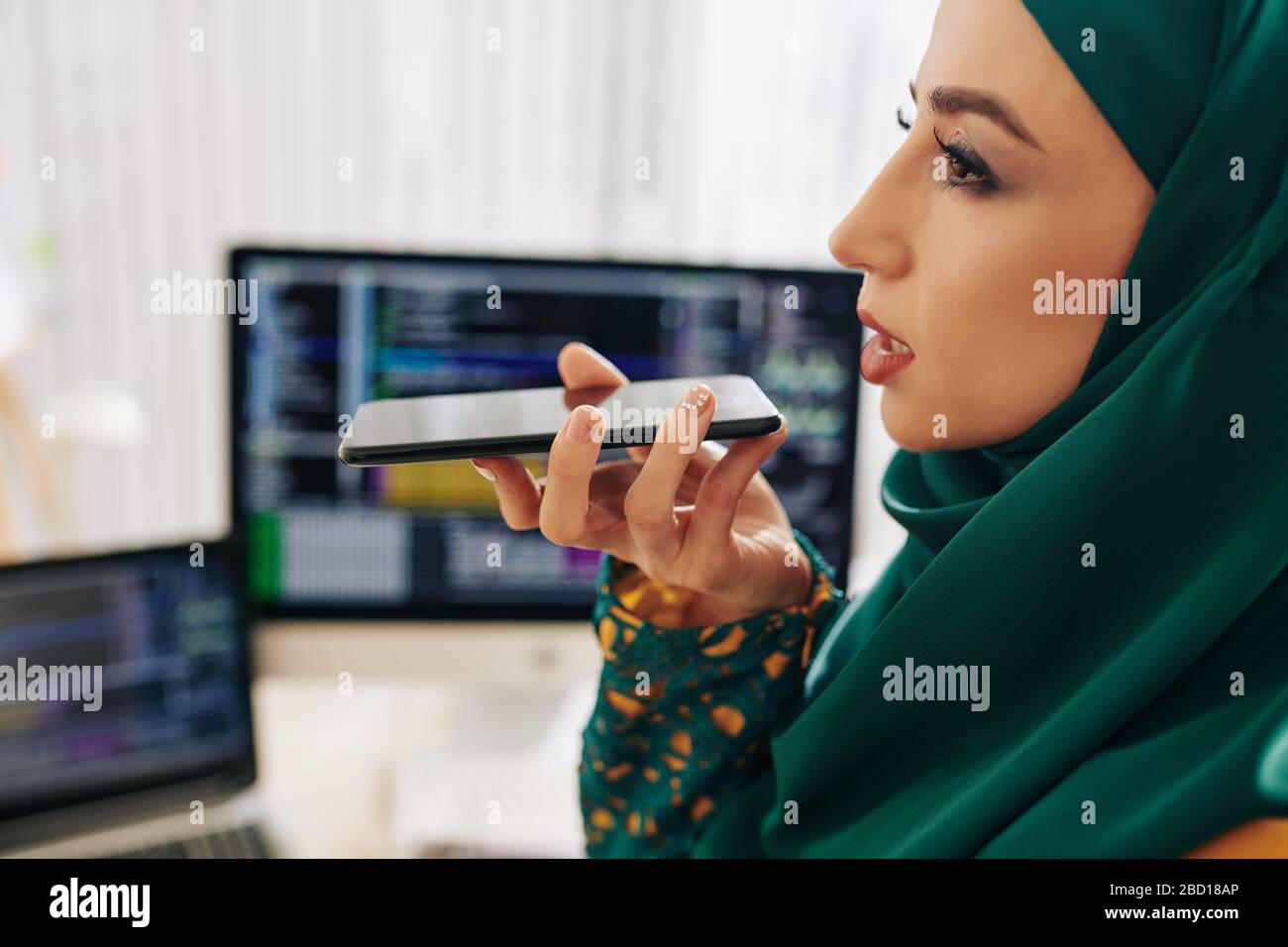 Beautiful muslim female software engineer recording voice message for ...