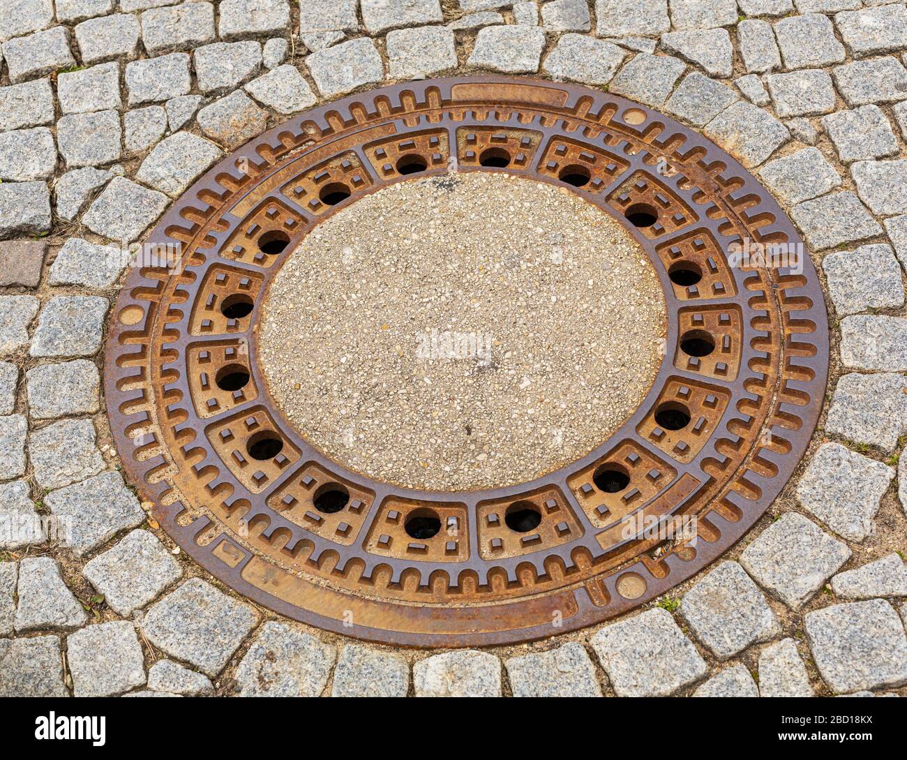 Sewer manhole cover. Urban infrastructure. Sewage system. Paving. Cast ...
