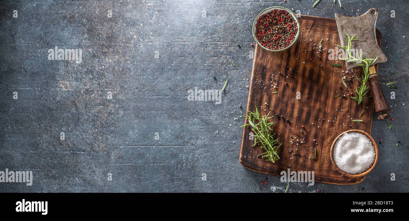 Top view of rectangular chopping board with preps and seasonings covering the right third of a ...