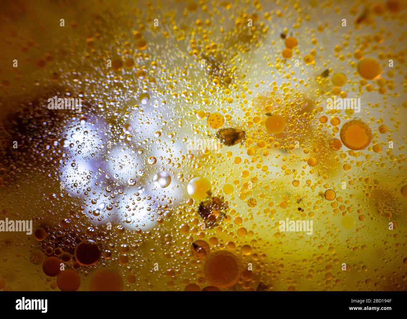 Yellow oil stains on the water. Olive in a frying pan. Macro images of ...