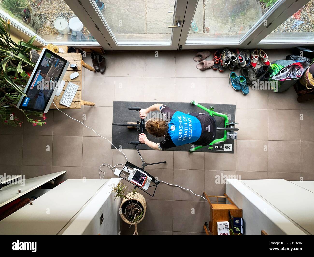 Teenage triathletes training on an indoor cycling turbo trainer and the ...