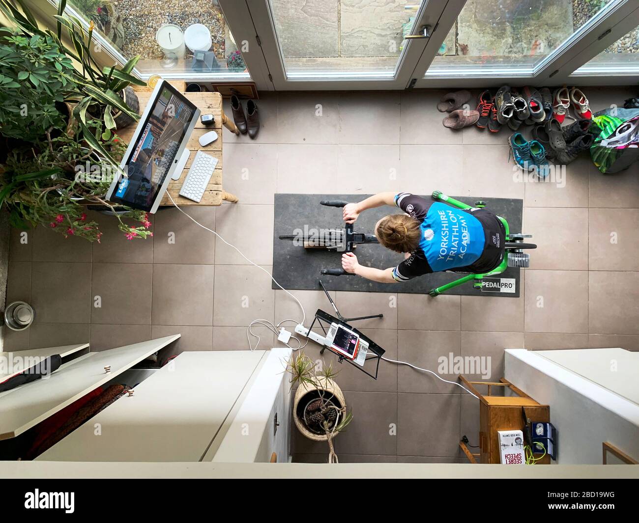 Teenage triathletes training on an indoor cycling turbo trainer and the ...