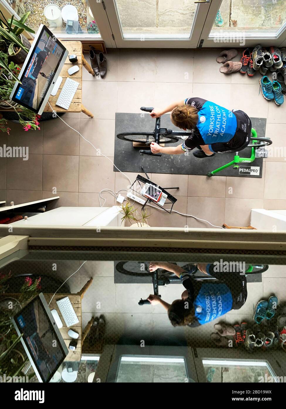 Teenage triathletes training on an indoor cycling turbo trainer and the ...