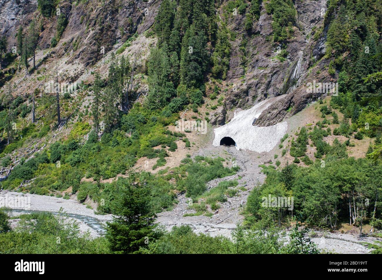 A natural snow cave on the side of a mountain Stock Photo - Alamy