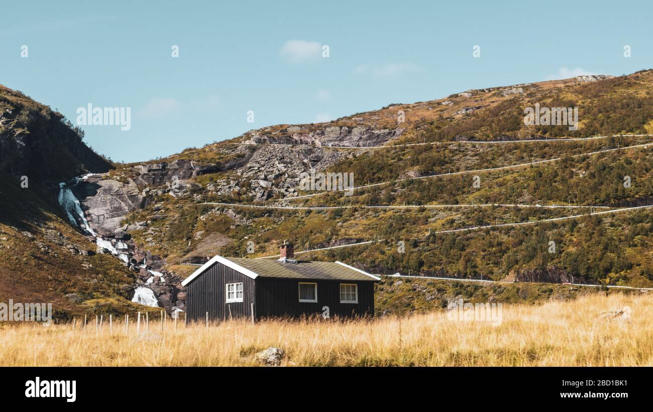 Norwegian traditional black house on serpentine mountain road on hill ...