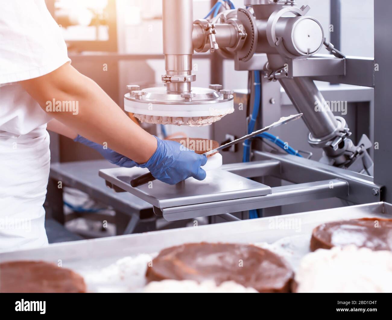 The pastry chef makes cake using modern equipment for the production of ...
