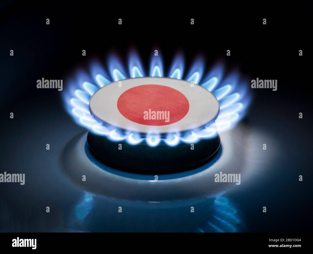 Burning gas burner of a home stove in the middle of which is the flag ...