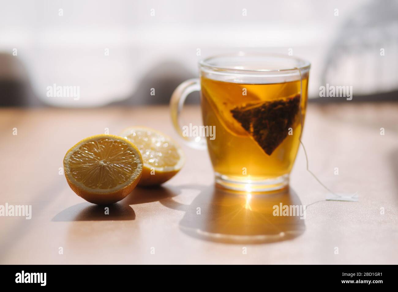 Black tea with lemon on wooden table. Tea bag with lemon slice in cup ...