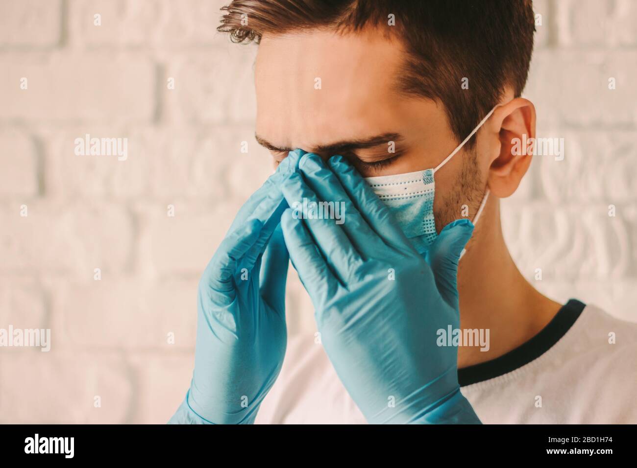 Frustrated tired man in protective gloves on hands and medical face ...