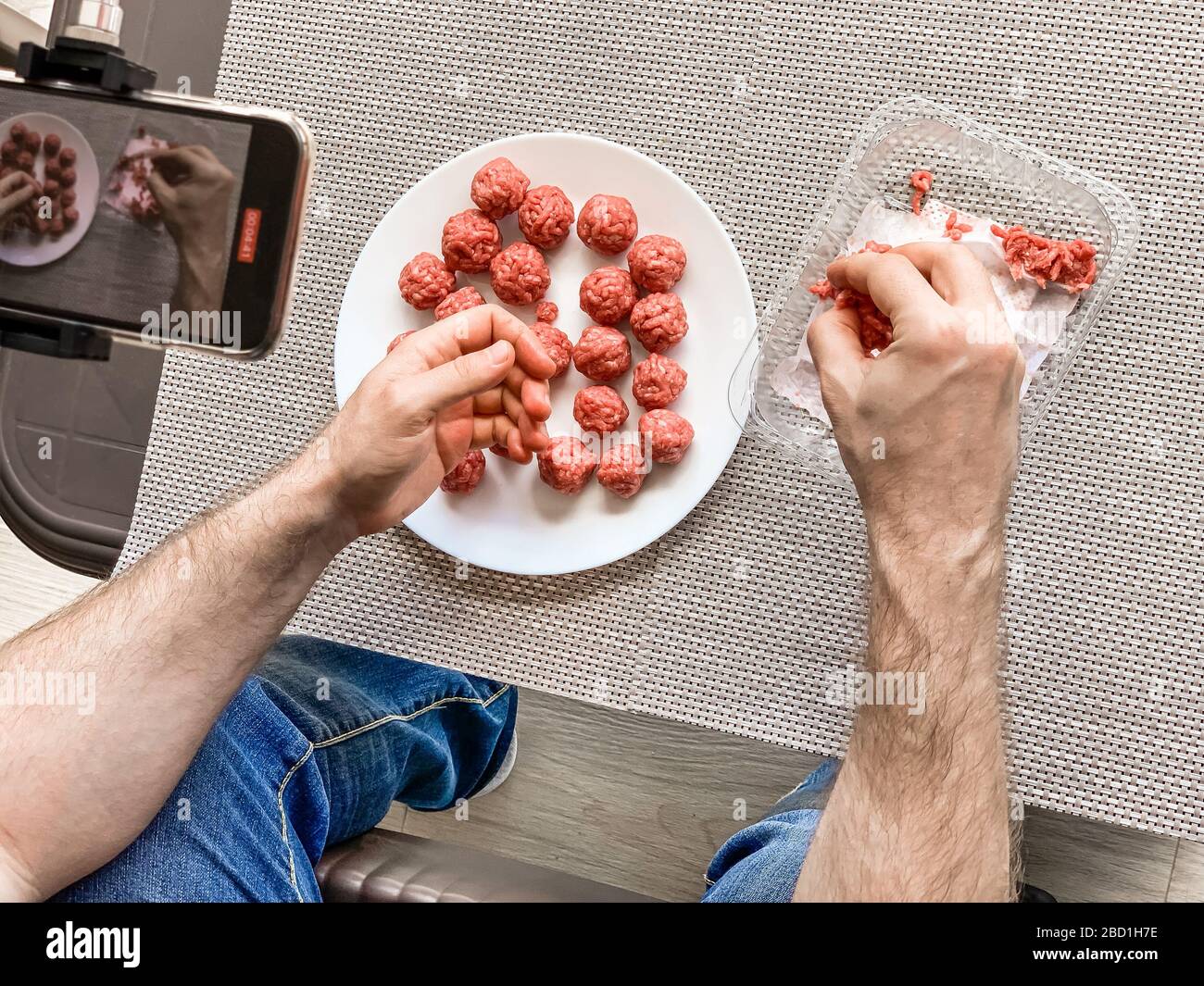 Man hands preparing meatballs with raw mincemeat recording video on ...