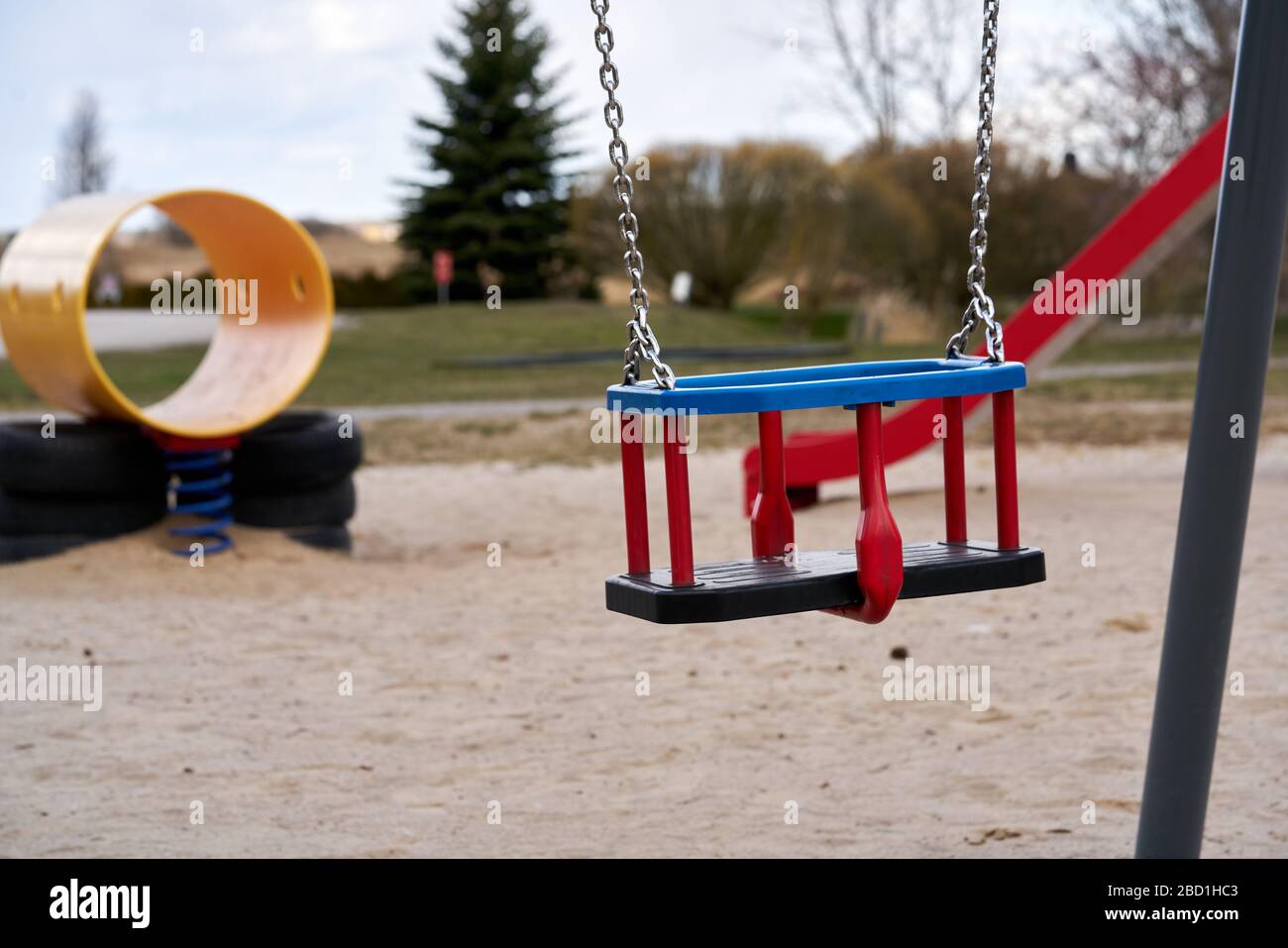 Colorful swings and rusty iron chain on cement block floor background ...