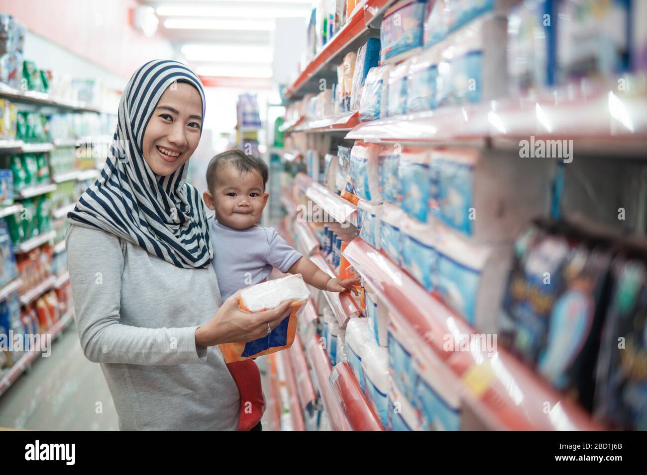 muslim asian Mother hijab and baby shopping in the supermarket. grocery ...