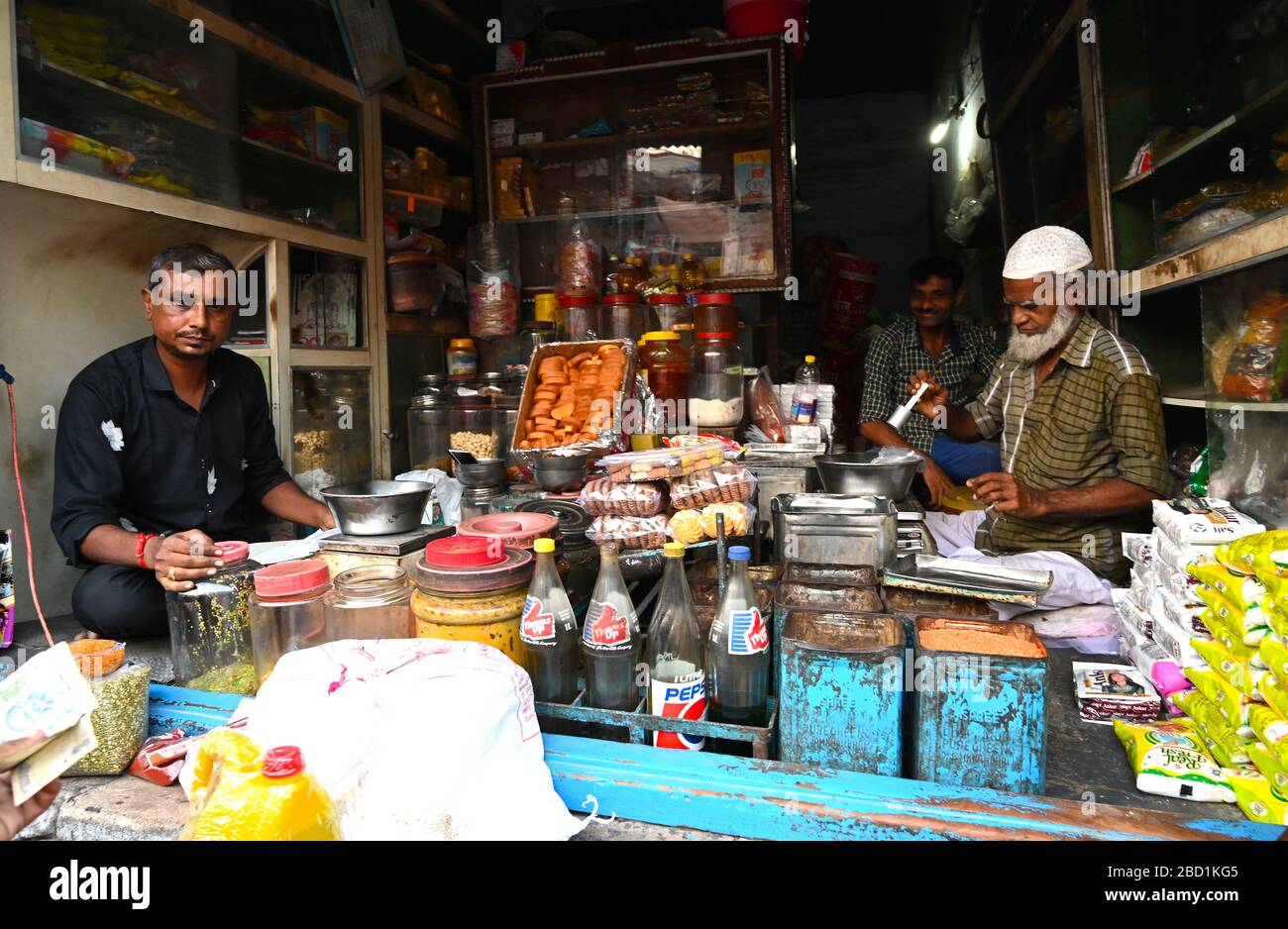 Village general stores, Muslim shopkeeper measuring honey for a ...