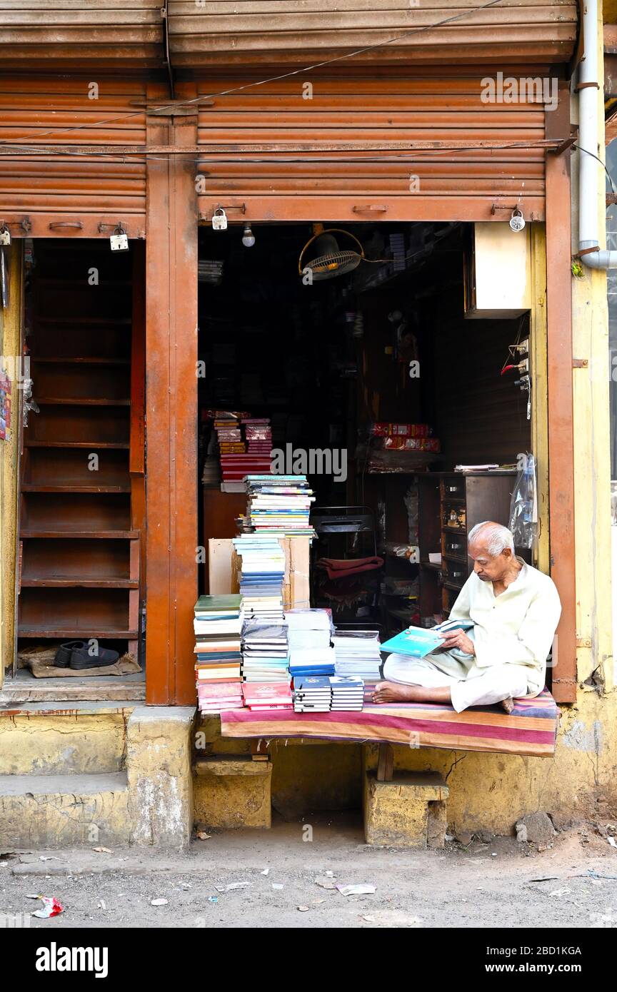Bookseller sitting outside his bookshop in old Ahmedabad, Gujarat ...