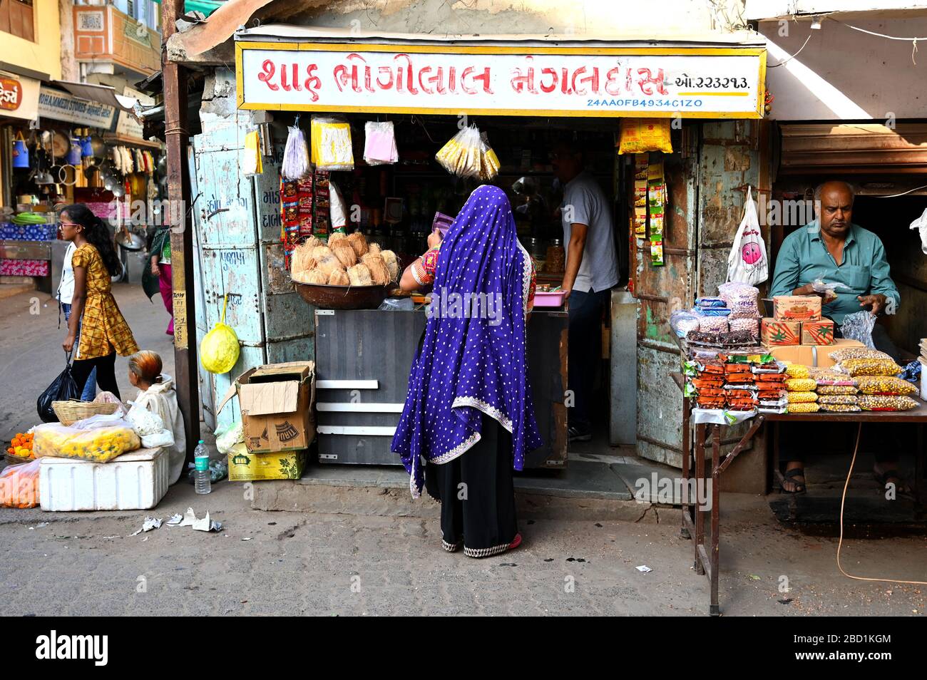 Hindu woman in purple dupatta shopping in the busy market, Bhuj ...
