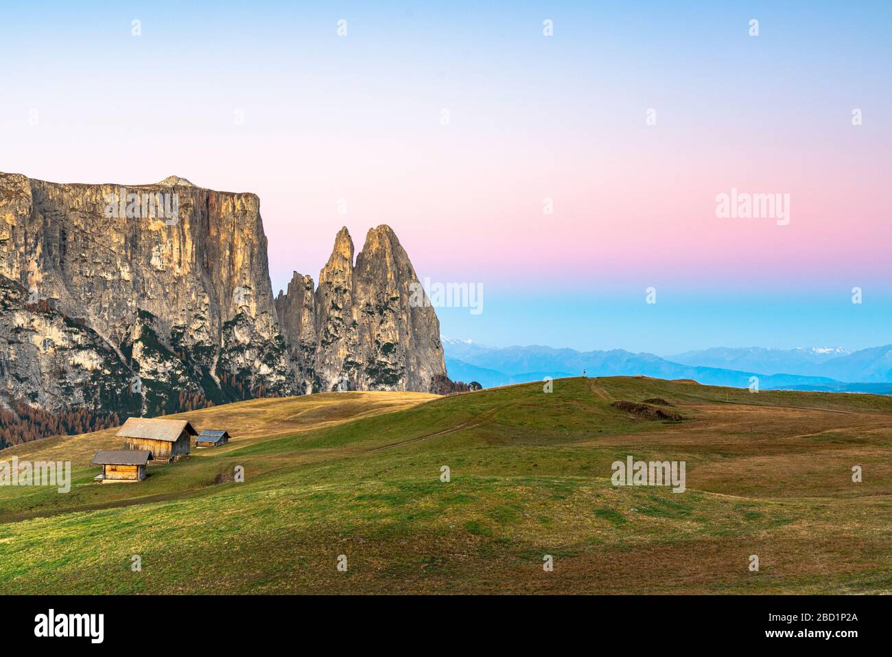 Autumn sunrise over Sciliar peaks and wood huts at Alpe di Siusi ...