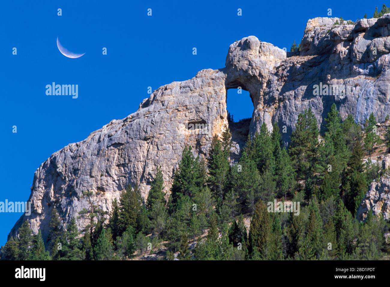 crescent moon over arch in limestone wall of the little belt mountains ...