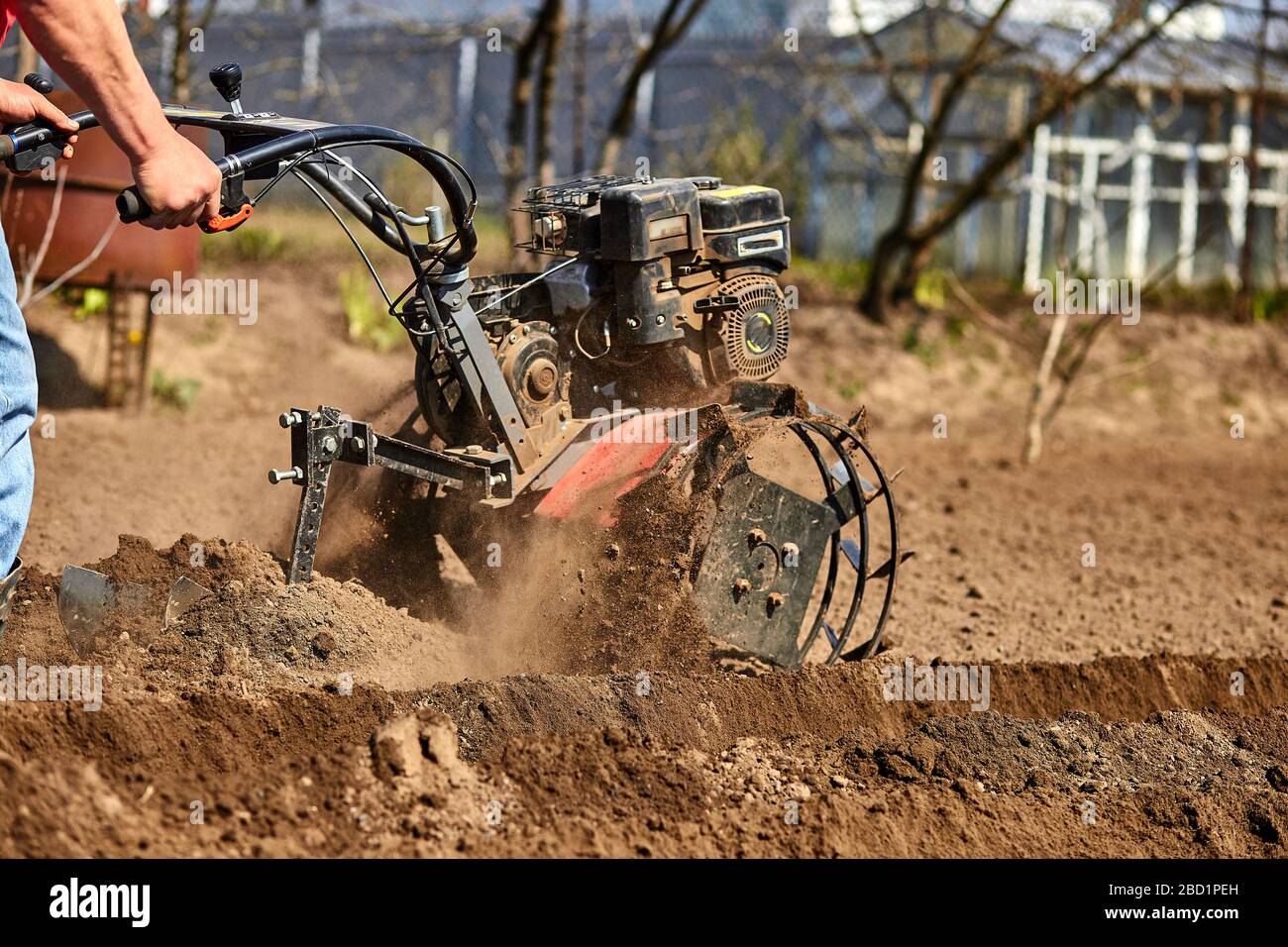 Man working in the garden with Garden Tiller. Garden tiller to work ...