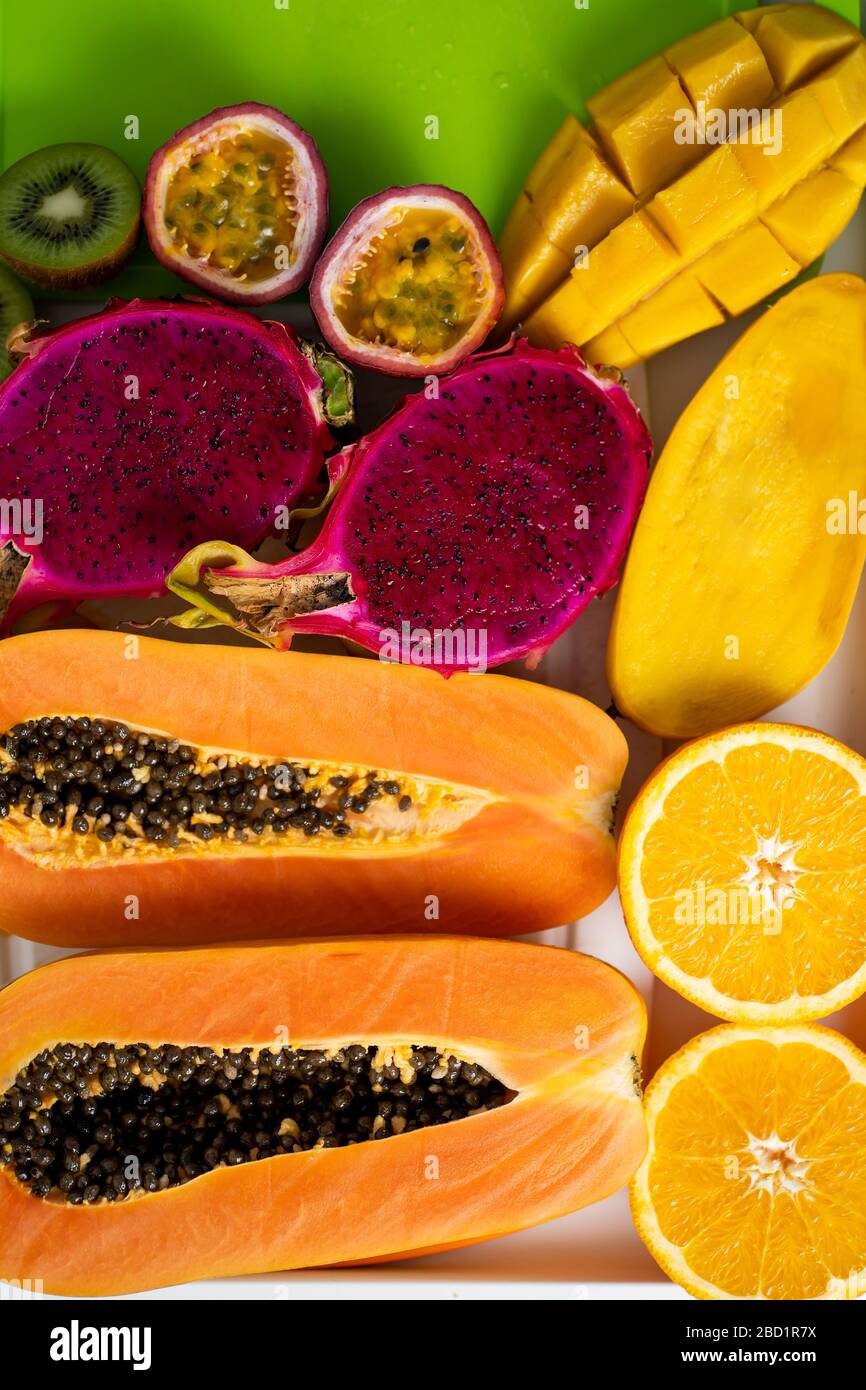 Assortment of sliced tropical exotic fruits on white tray. Top view ...