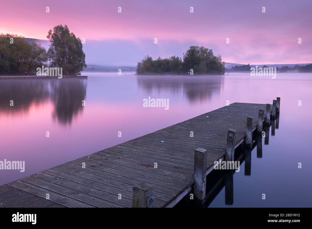 Pink sunrise over Llangorse Lake in the Brecon Beacons National Park ...