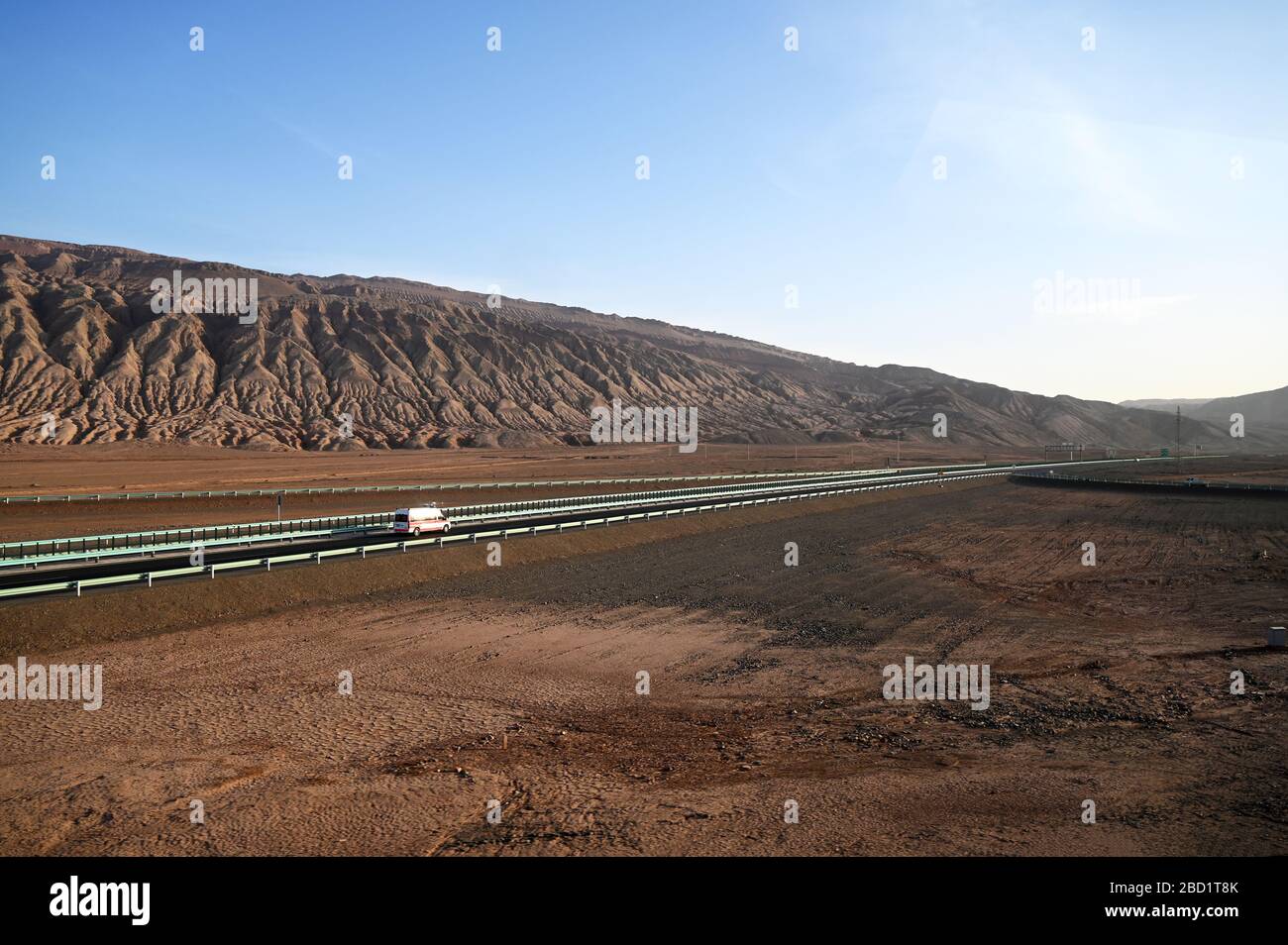 Police vehicle driving along the deserted Silk Road in the Gobi desert ...