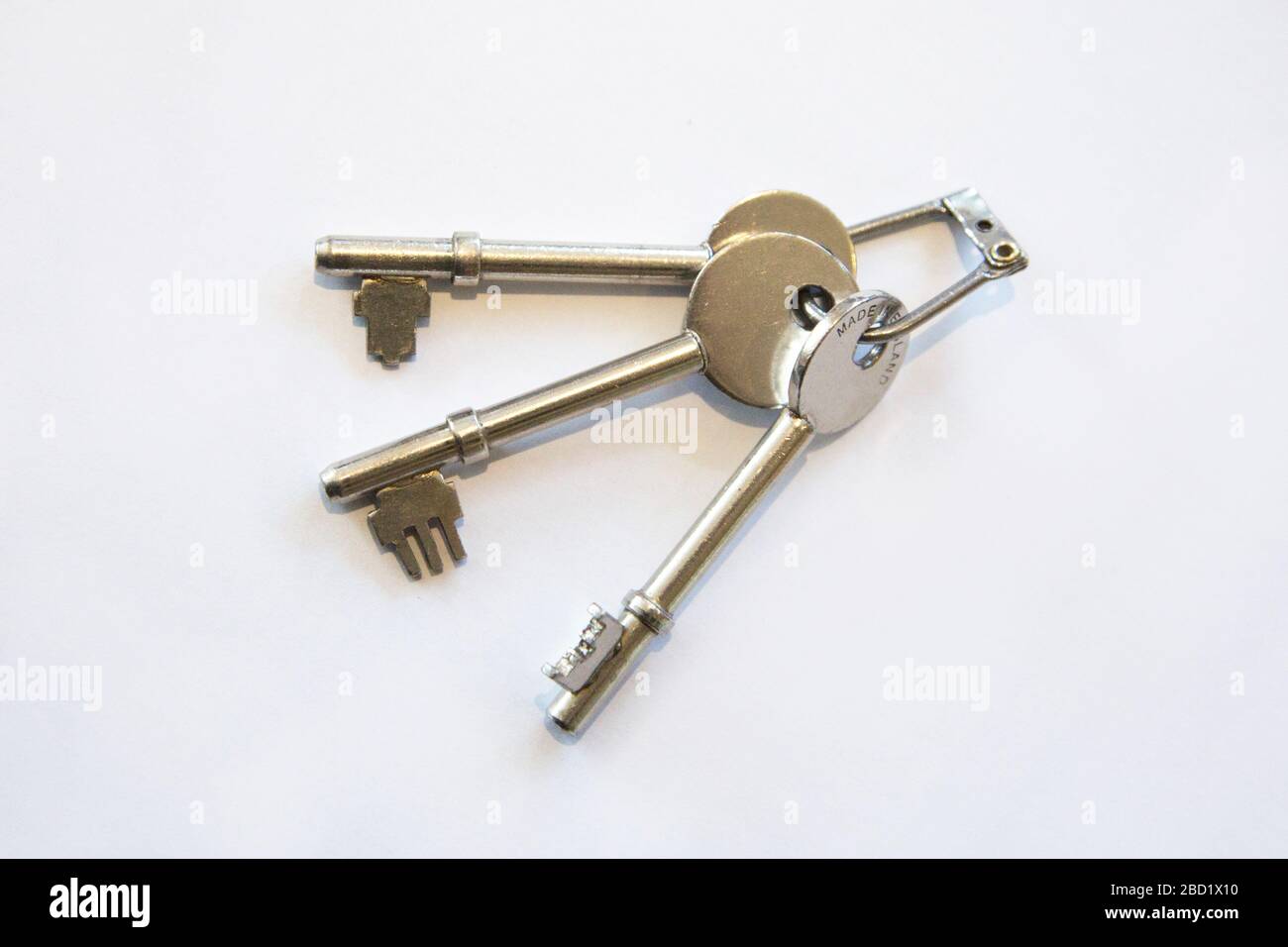 set of three silver door keys on a white background, house keys on ...