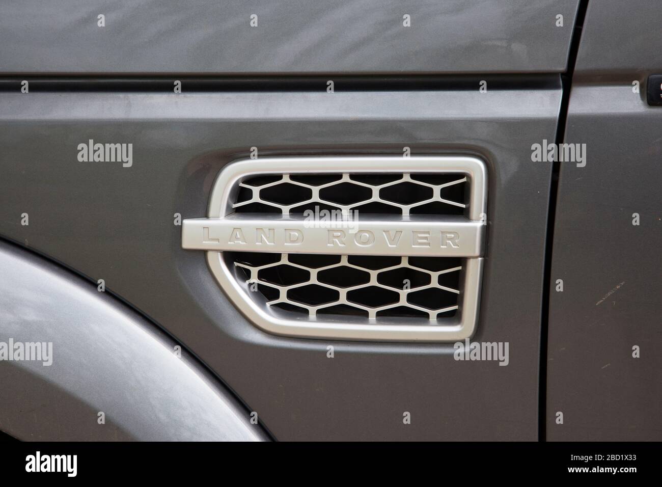 close up of Land Rover grill on side of grey Discovery in the daytime ...