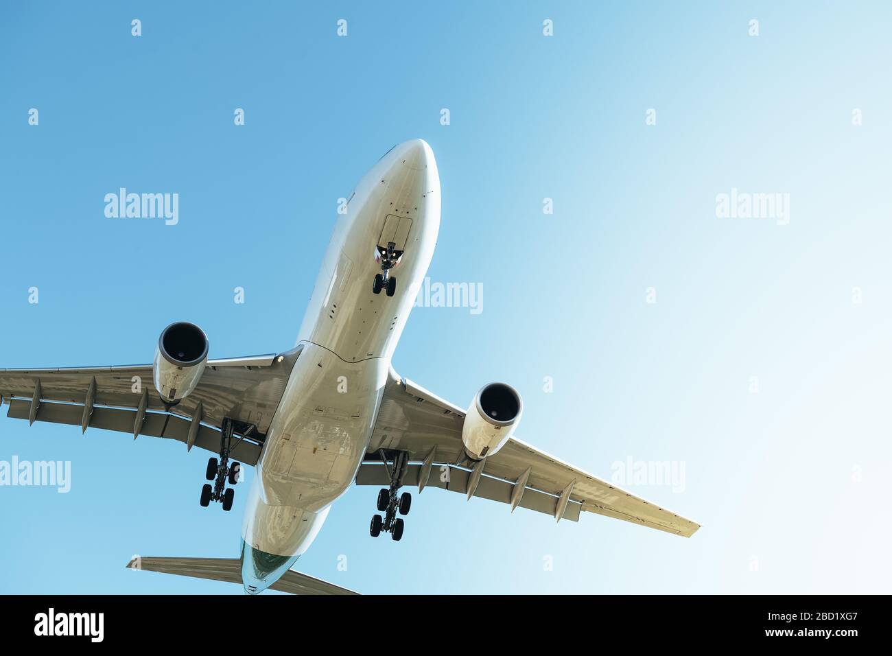 commercial aircraft seen from below with the landing gear deployed ...