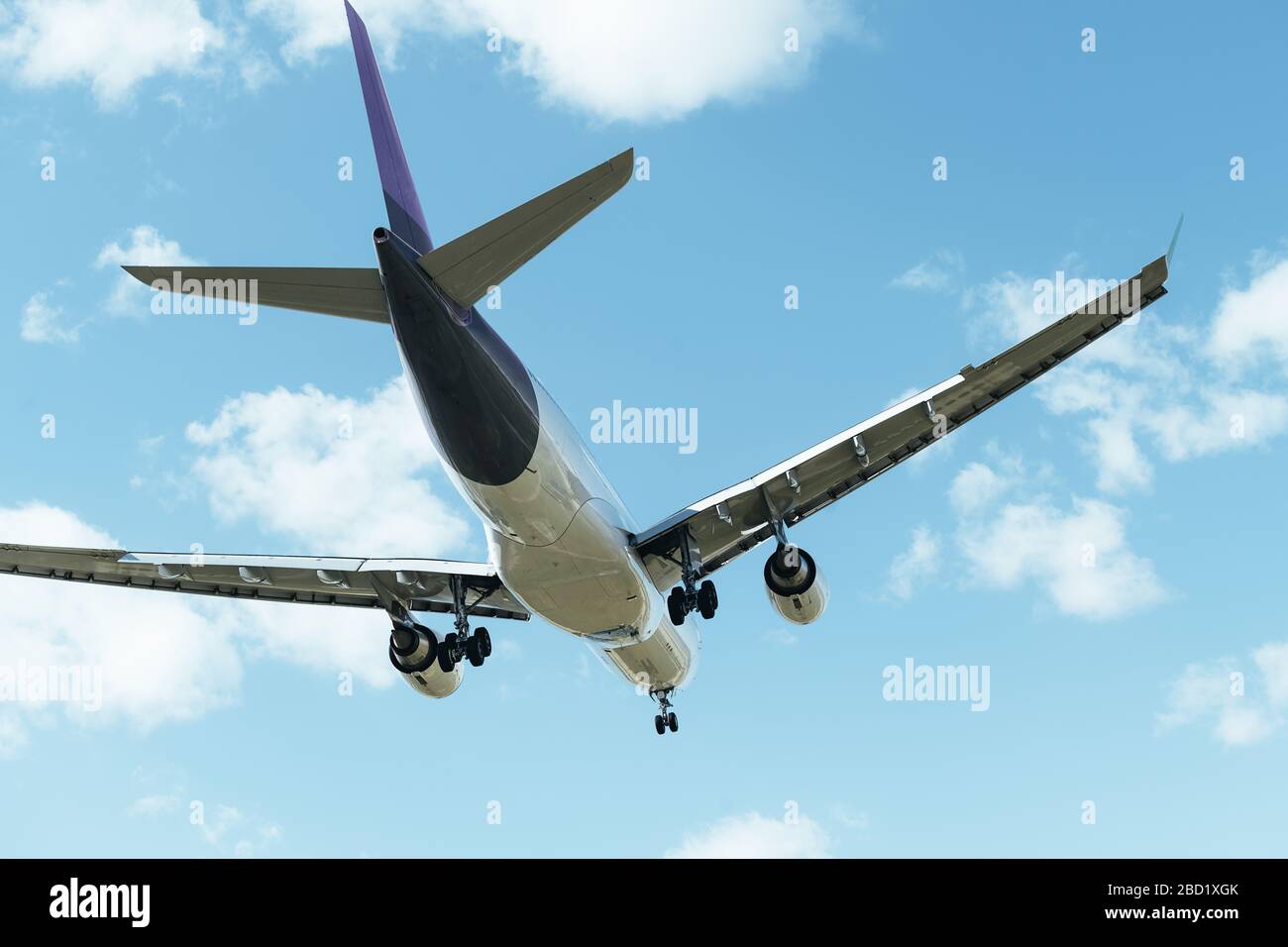commercial aircraft flying seen from behind with the landing gear ...