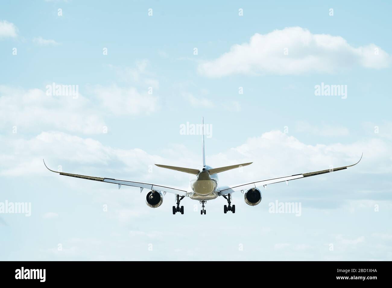 rear view of a commercial plane flying in a clear blue sky with some ...