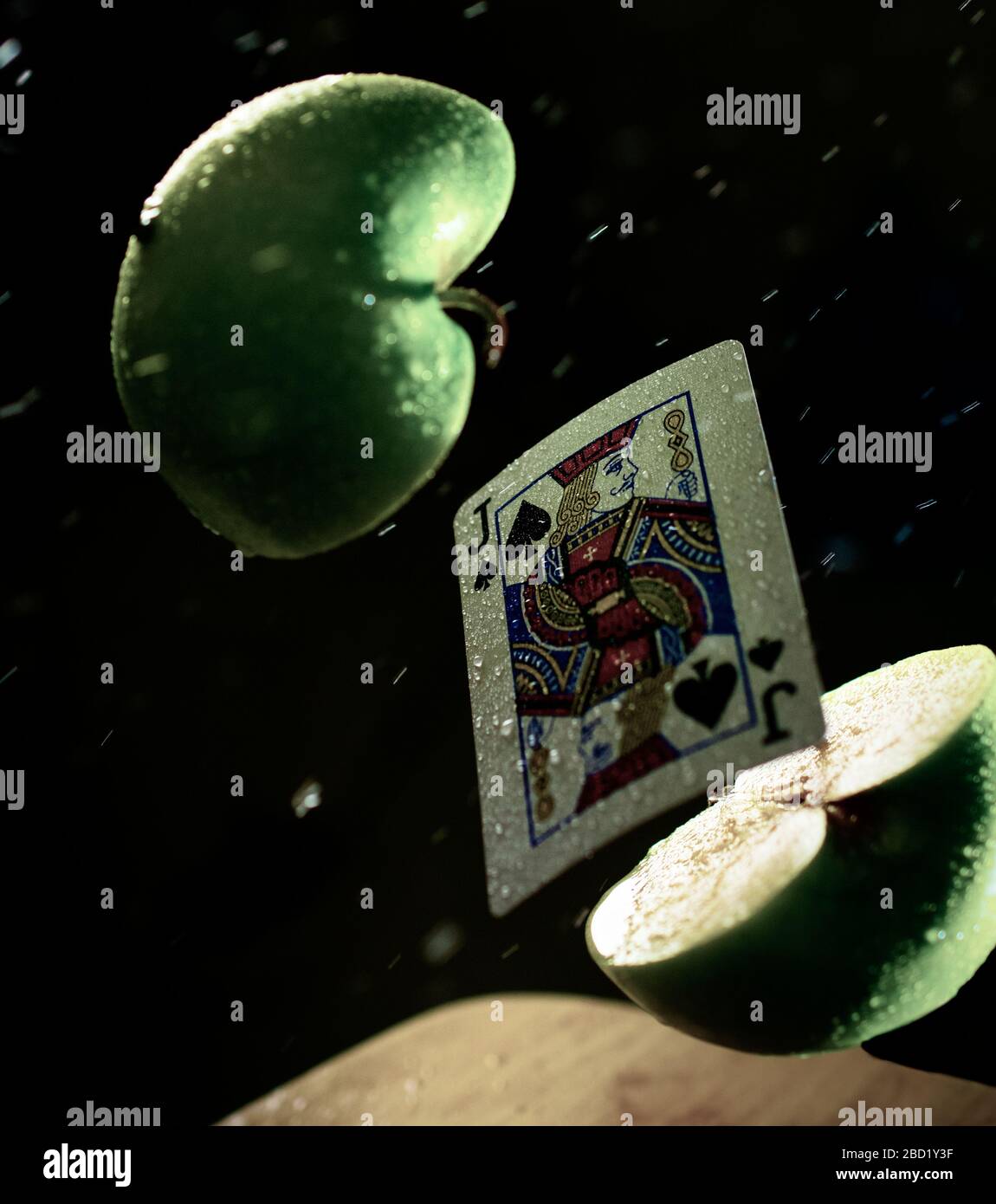 green apple cut in half by throwing a card Stock Photo - Alamy