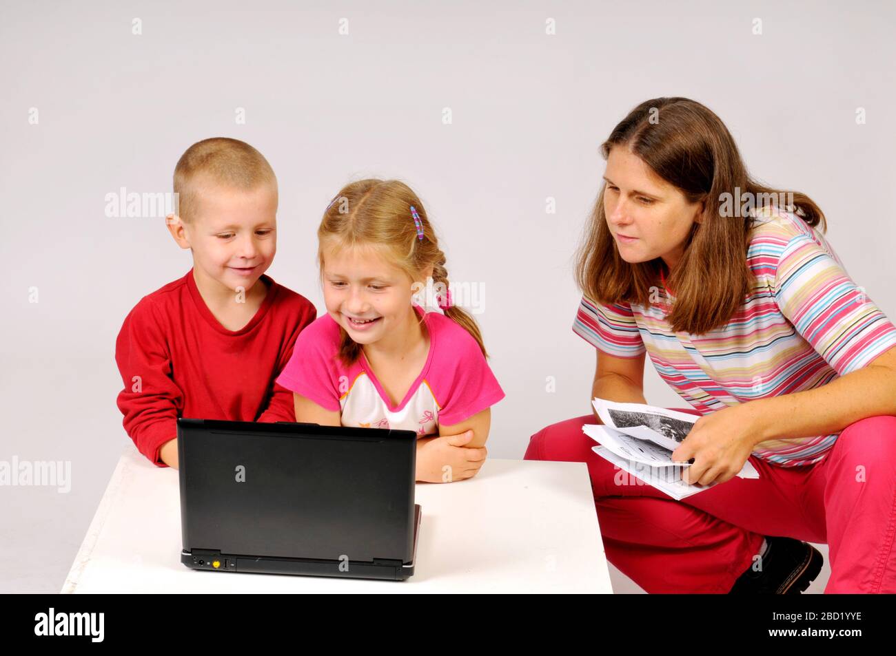 The two little children with notebook with mother Stock Photo - Alamy