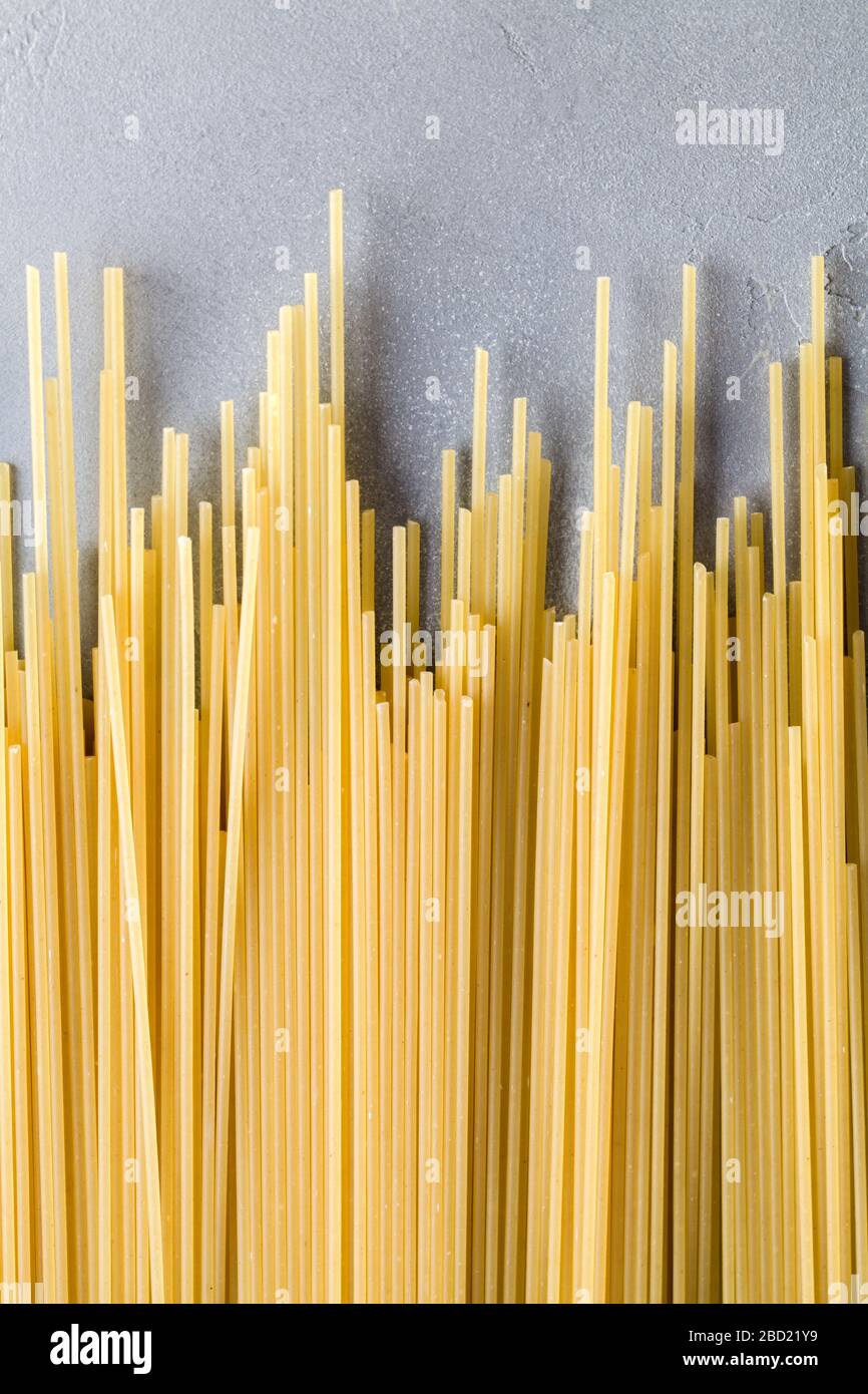 Yellow long spaghetti on blue background. Raw spaghetti bolognese. Raw ...