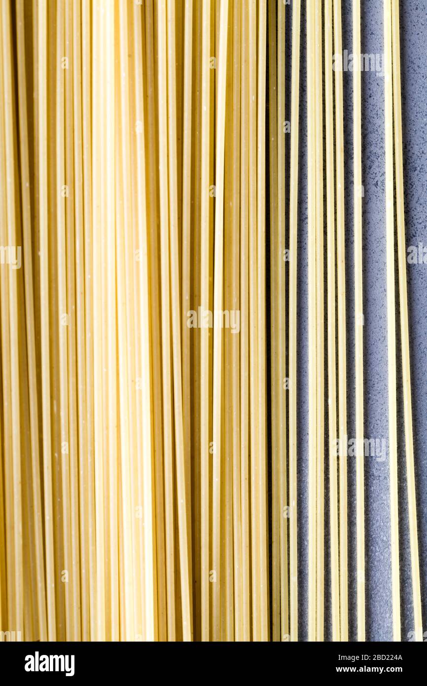 Yellow long spaghetti on blue background. Raw spaghetti bolognese. Raw ...