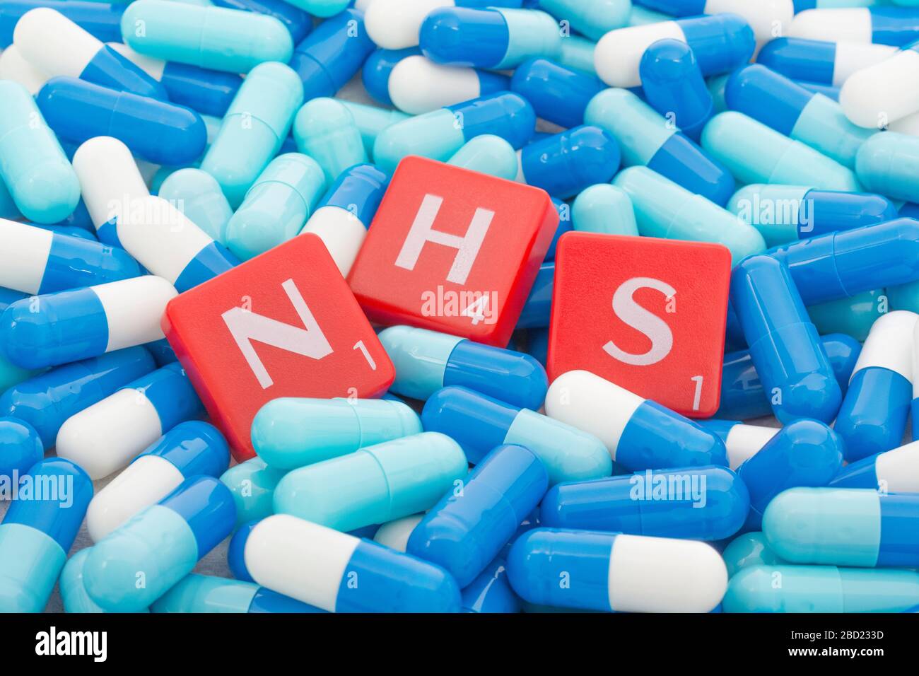 NHS letters tiles sinking into pills. For NHS overwhelmed by Covid 19 ...