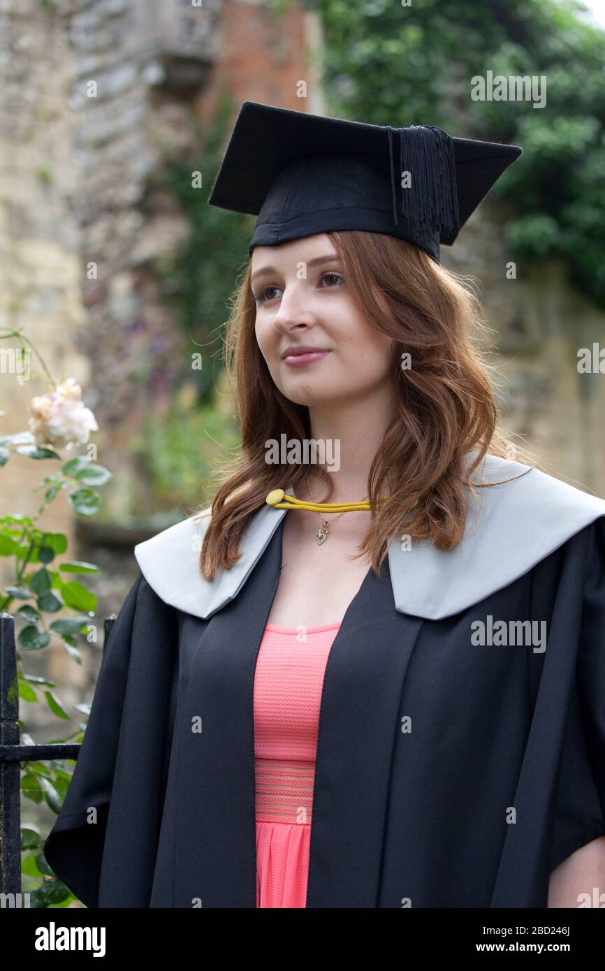 Pretty female university graduate posing outdoors after graduation ...