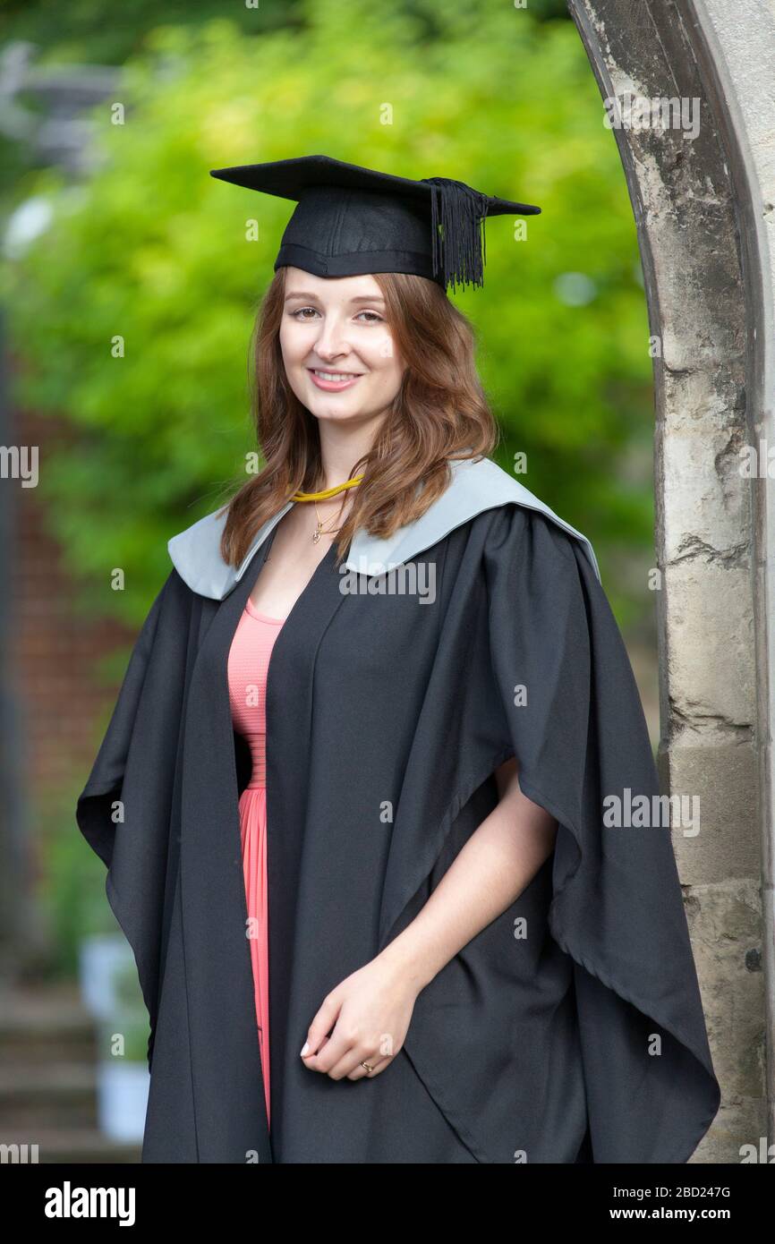 Pretty female university graduate posing outdoors after graduation ...