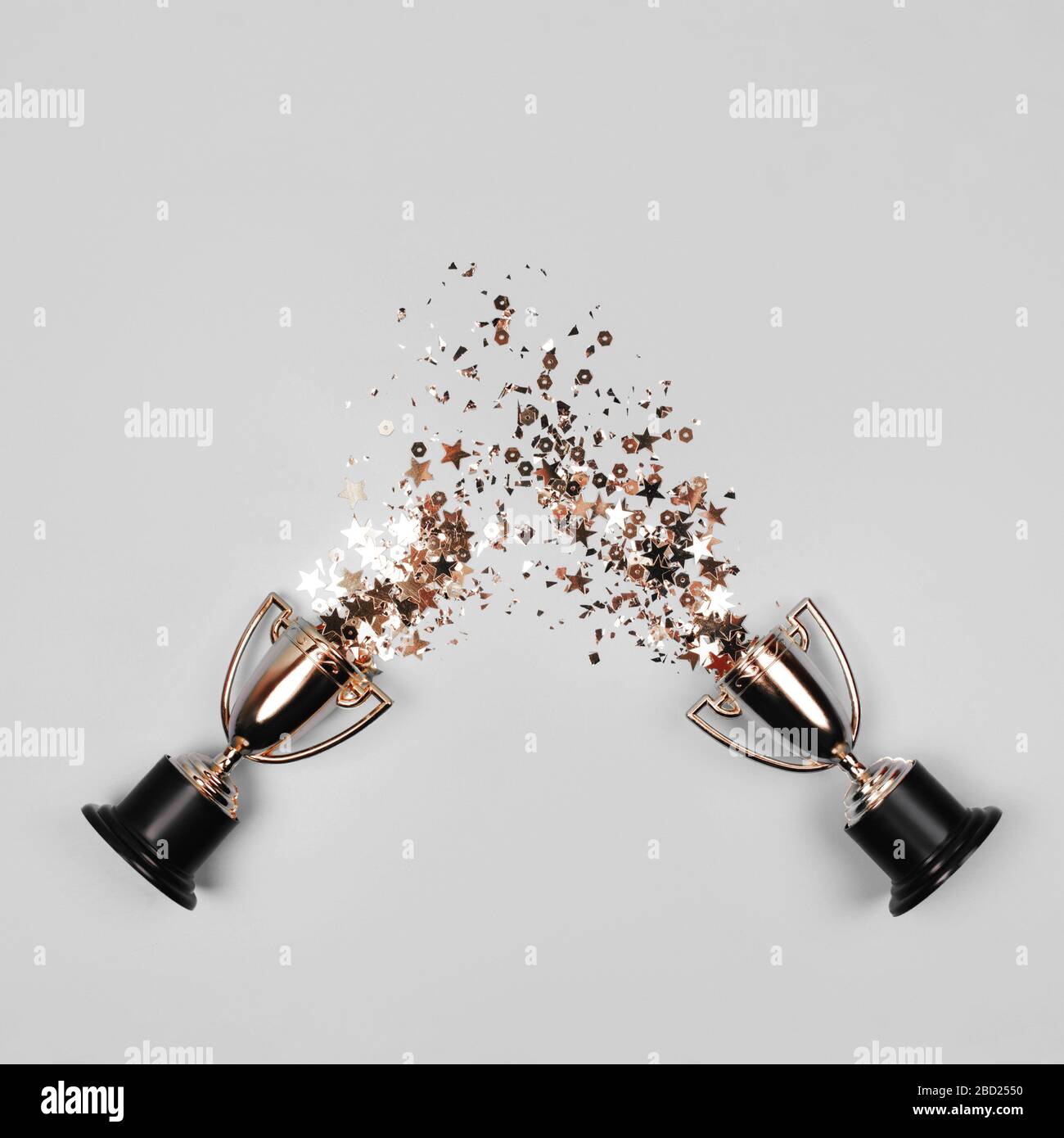 Winner cups with golden sparkles on a pastel background. Flat lay style ...